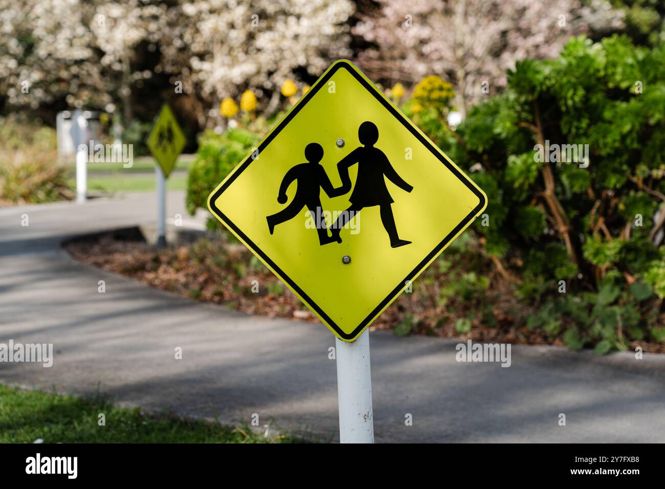 Bright yellow children crossing sign in park Stock Photo - Alamy
