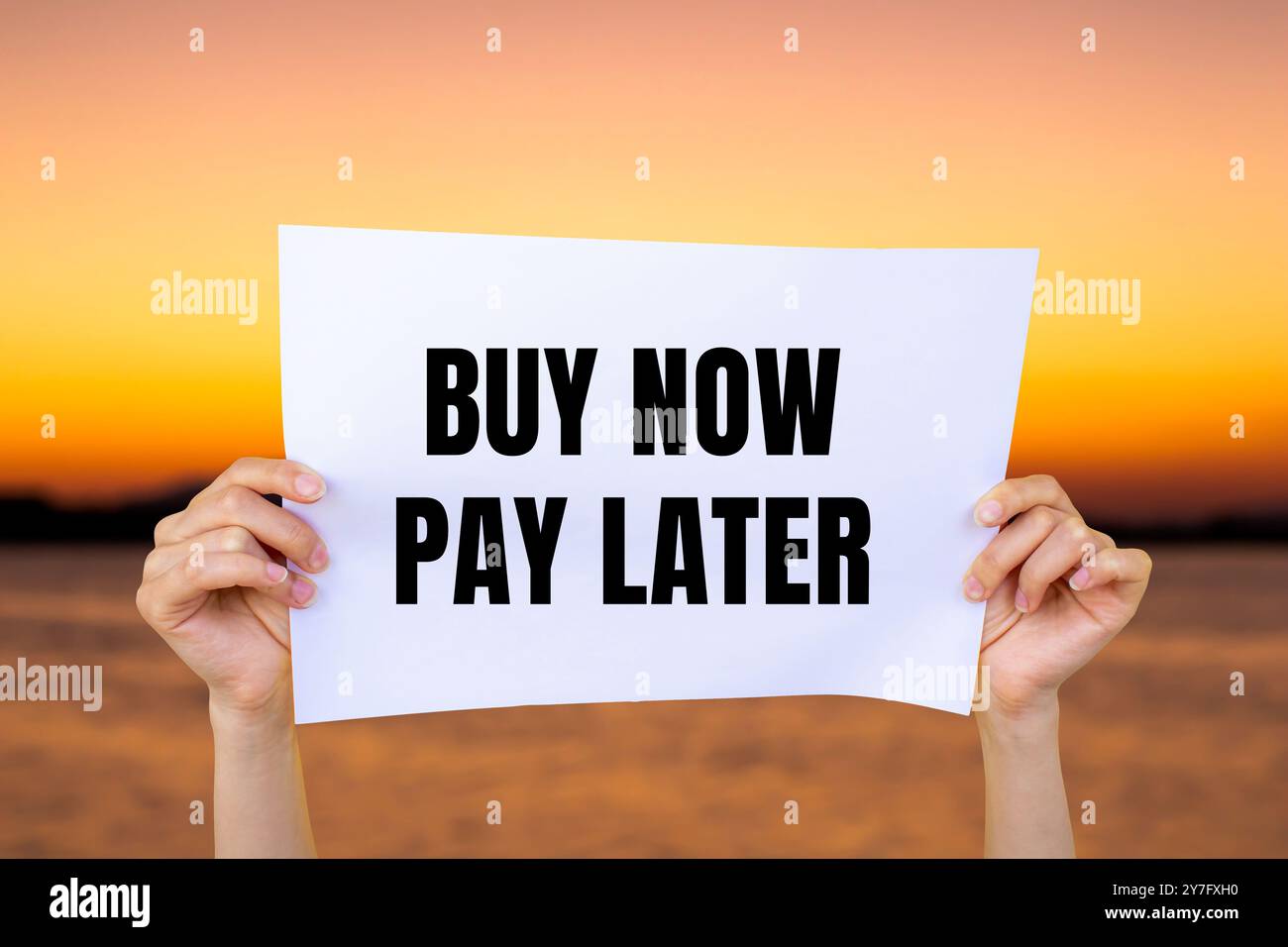 Buy now pay later message written on white paper with blurry lake ...