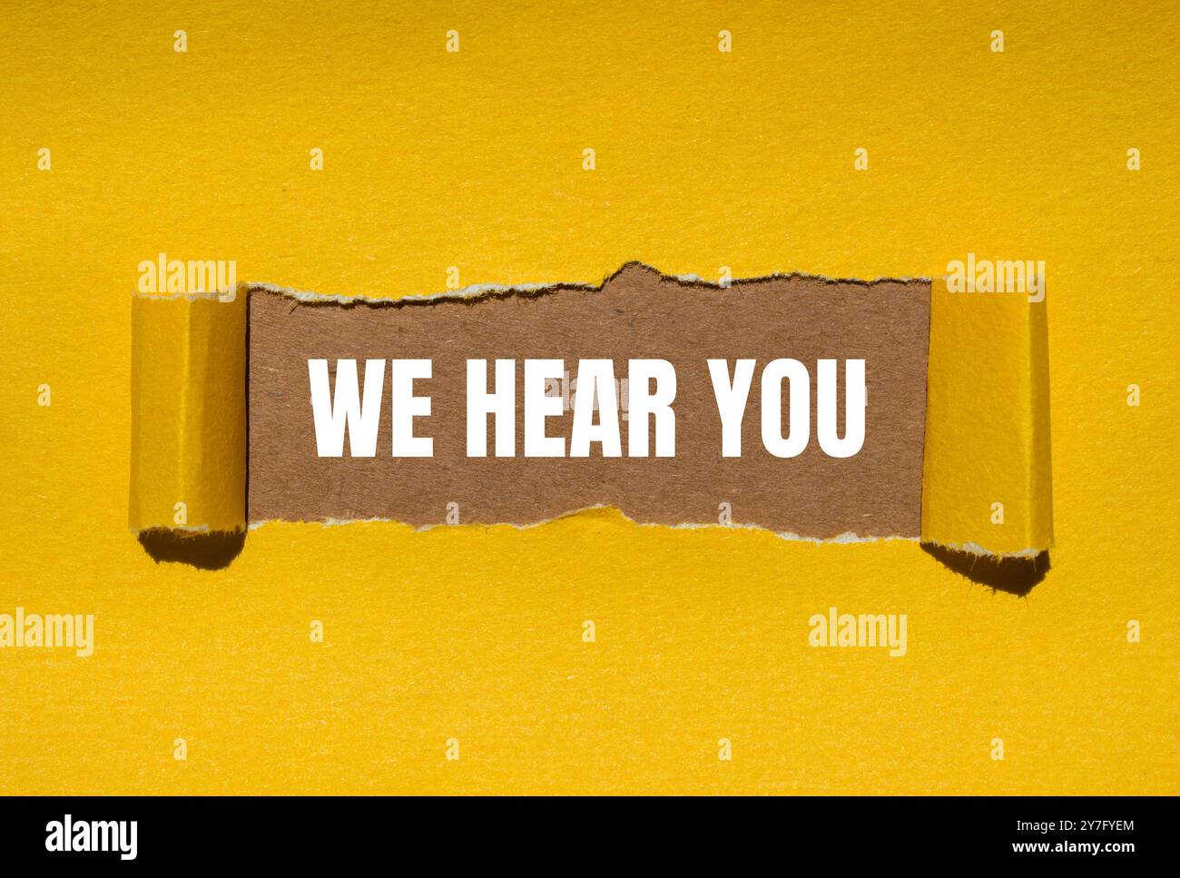 We hear you message written on ripped torn yellow paper with brown ...