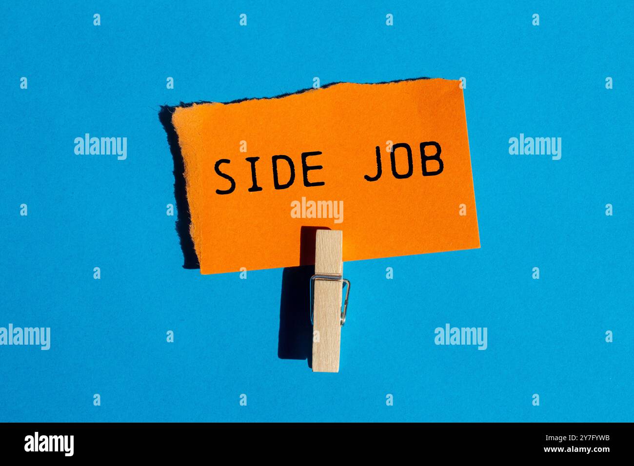 Side job message written on ripped torn orange paper on blue background ...
