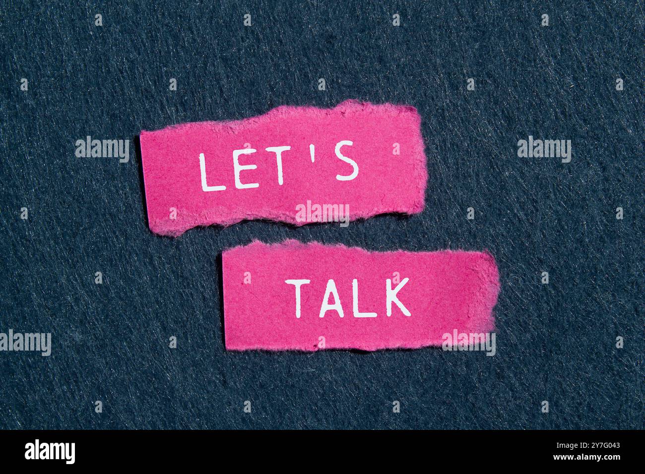 Let's talk message written on ripped torn pink paper pieces on gray ...