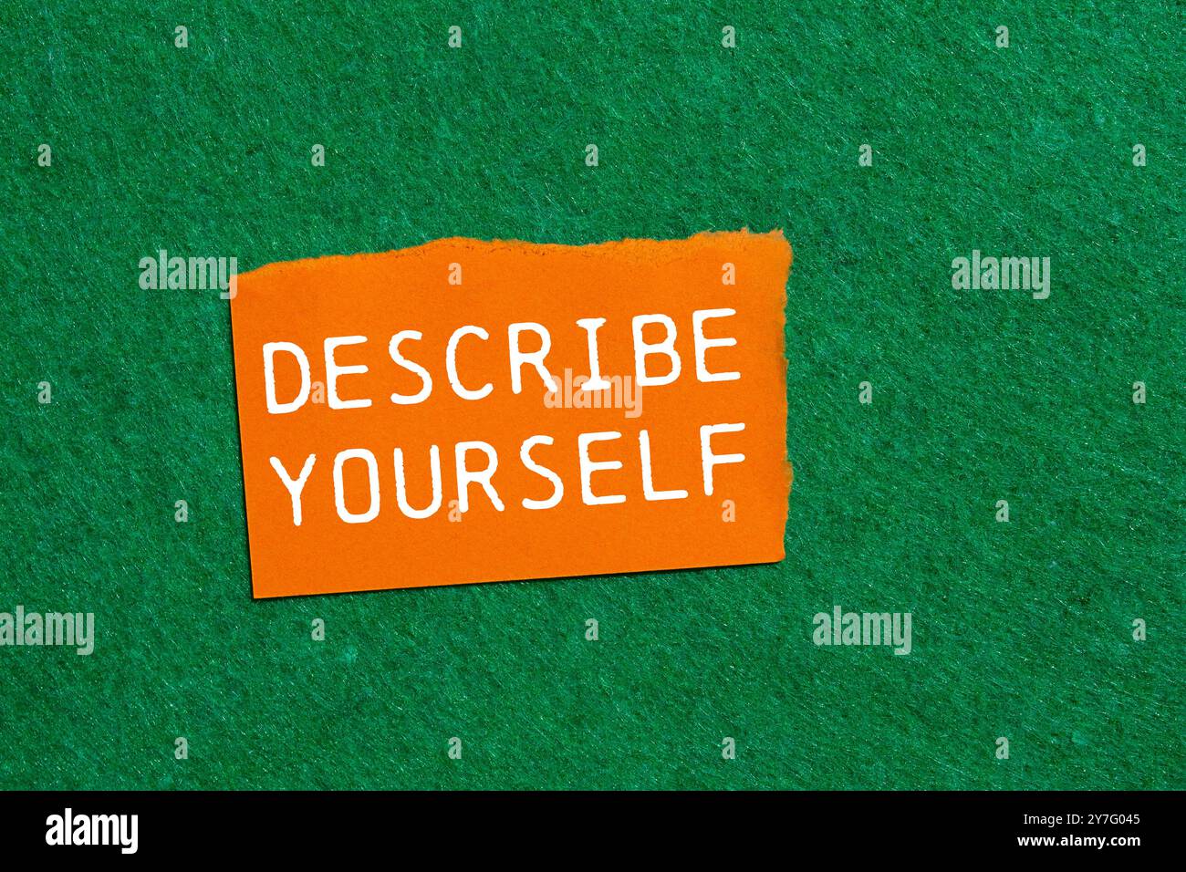 Describe yourself message written on ripped orange torn paper piece on ...