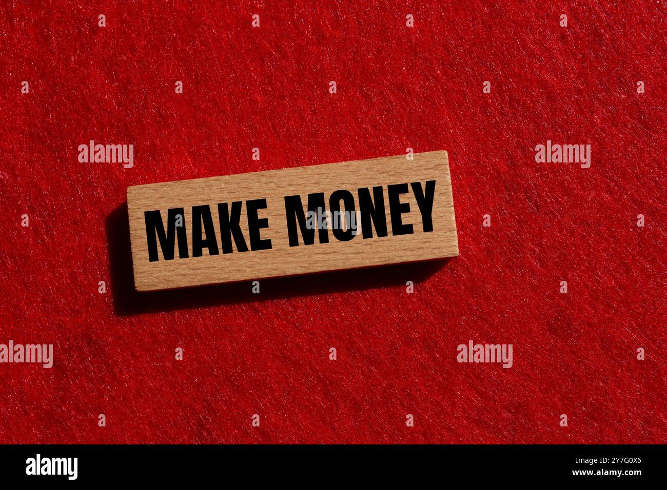 Make money message written on wooden block with red felt background ...