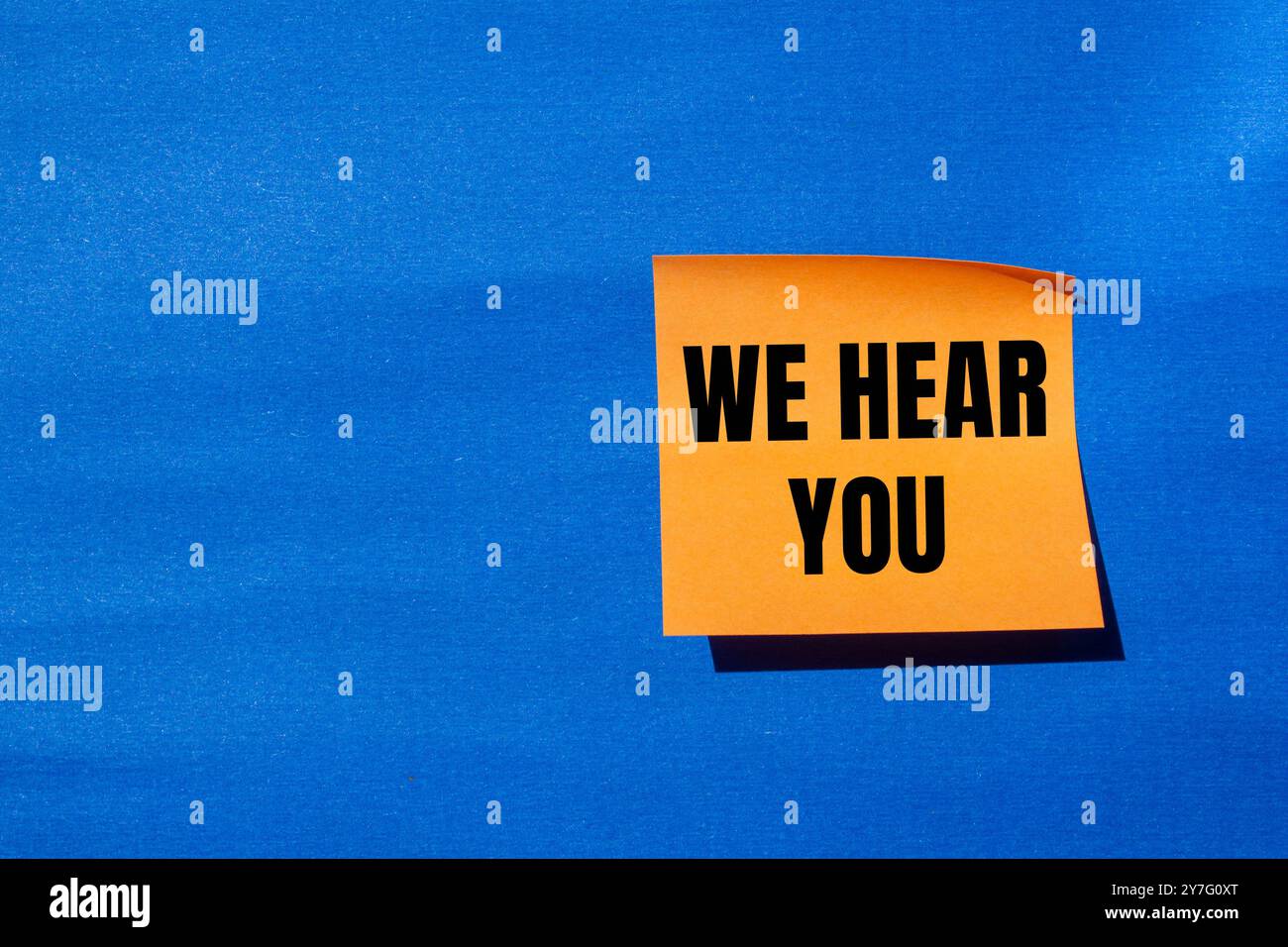 We hear you message written on orange paper with blue background ...