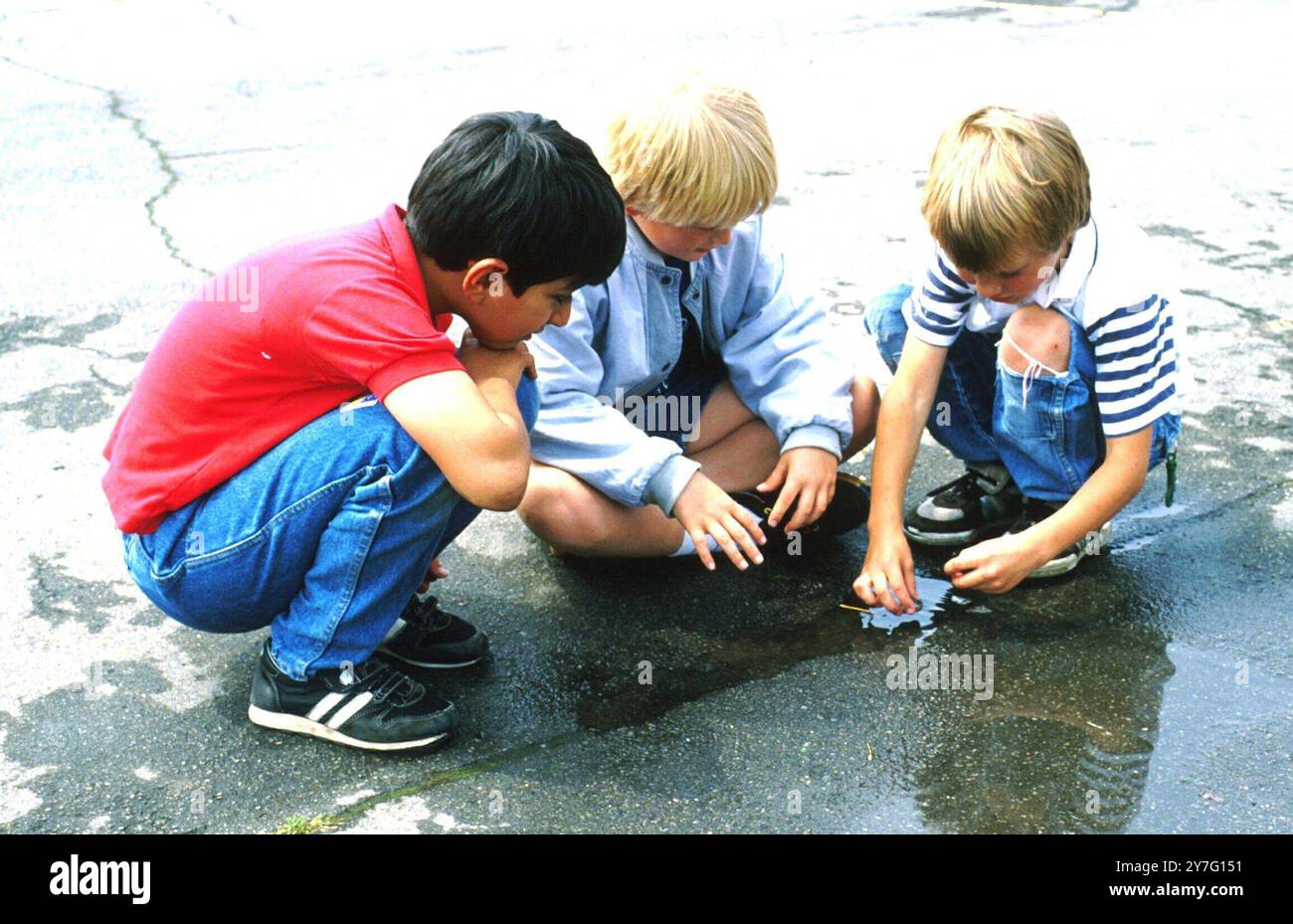 Primary School boys playing during break time matchstick boats Stock ...