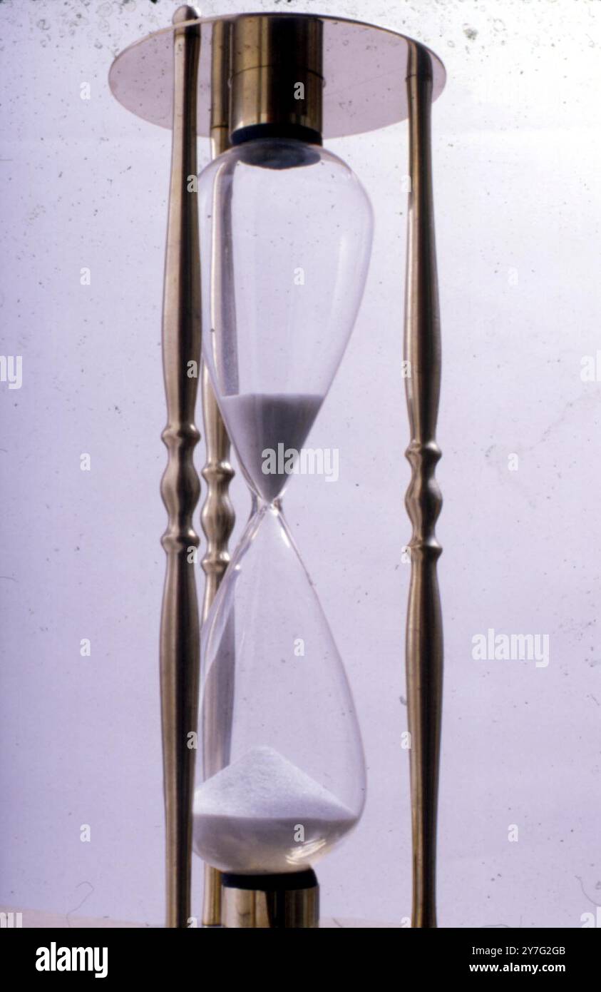 Sand running through an hour glass Stock Photo - Alamy