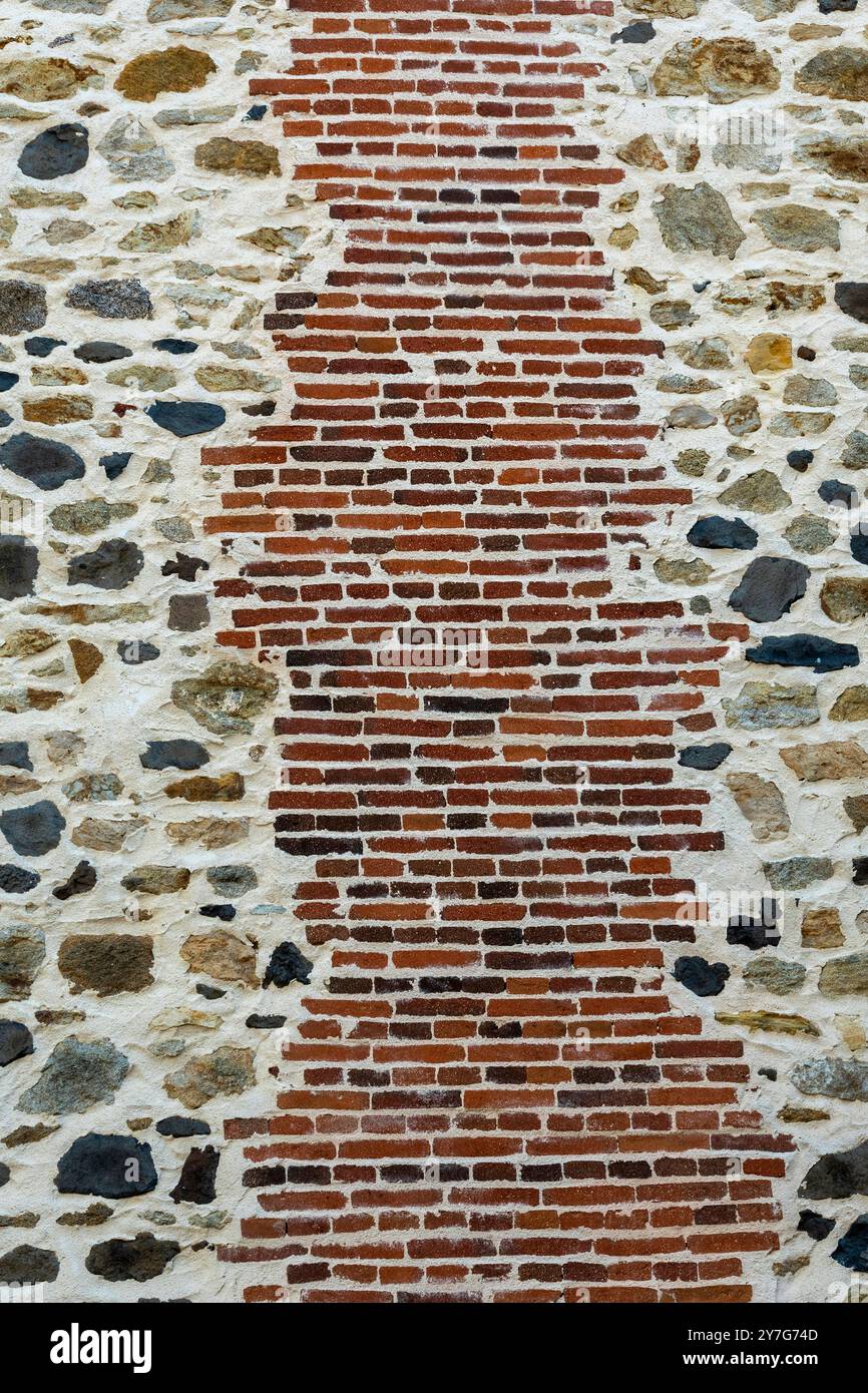 A brick pattern within a textured stone wall showcasing construction ...