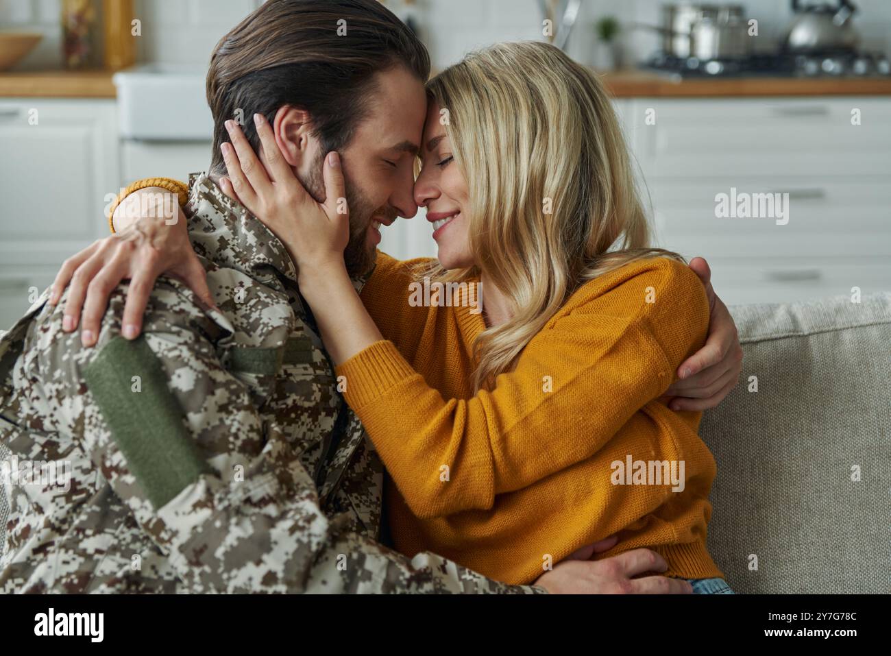 Cheerful man in military form hugging his wife after coming home from ...
