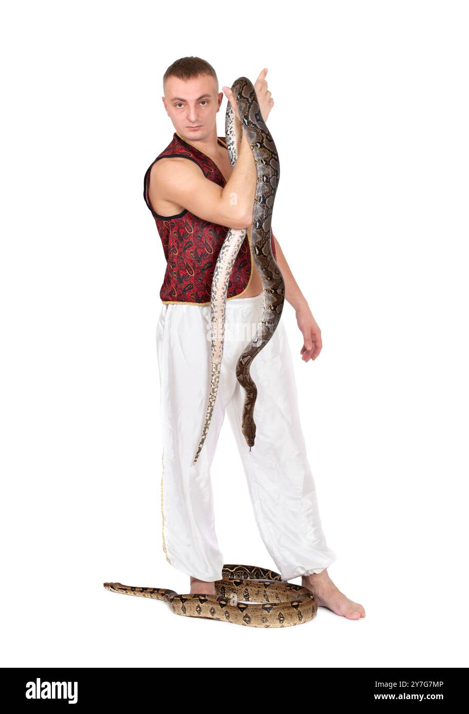 Young Caucasian man in Eastern costume interacting with two snakes ...