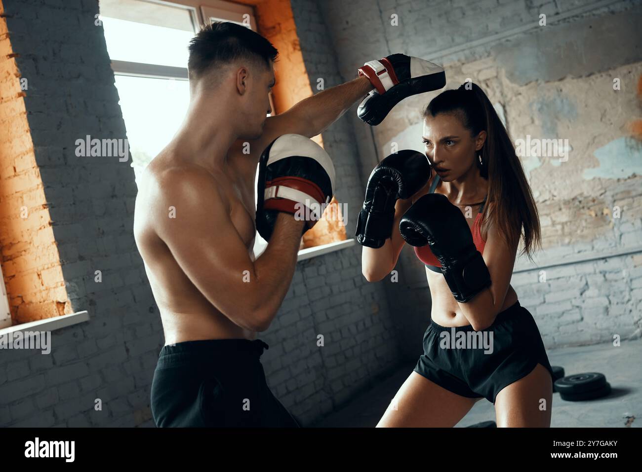 Concentrated young woman boxing with personal coach in gym Stock Photo - Alamy