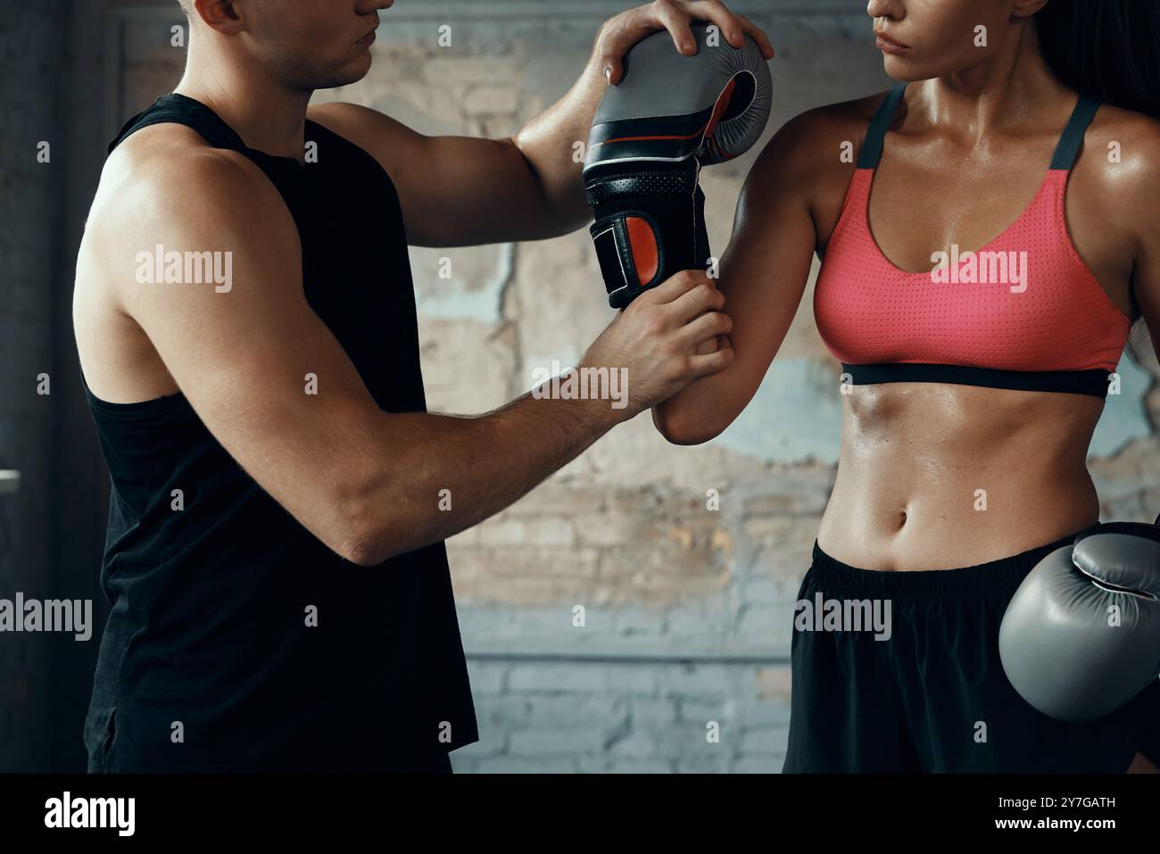 Close-up of male coach helping woman to wear boxing glove in gym Stock Photo - Alamy