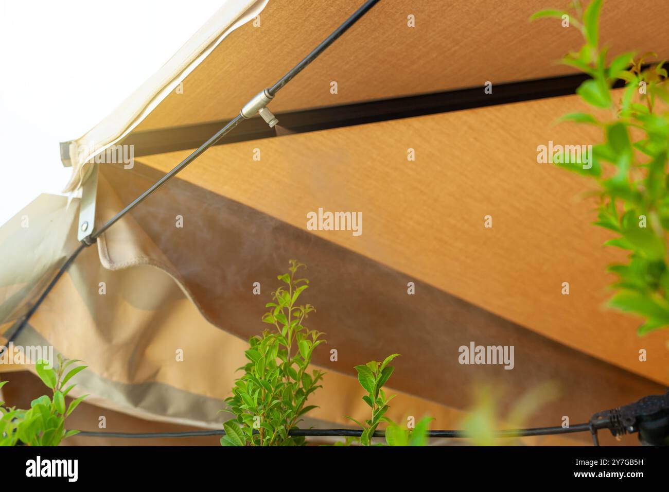 Water misting system spraying a refreshing cool mist over a terrace ...