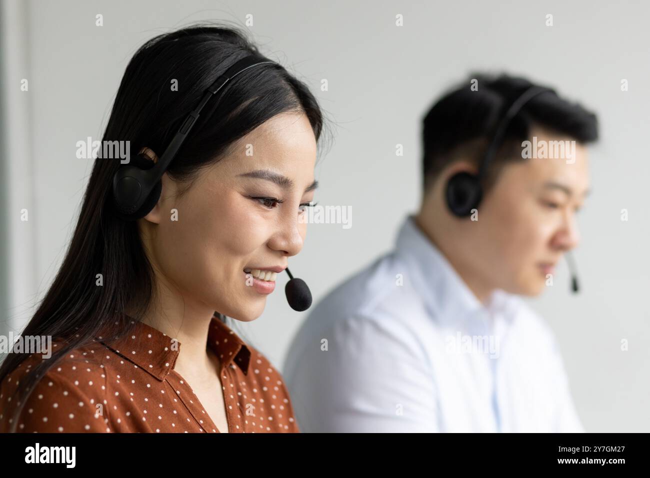 Customer service representatives wearing headsets engaged in communication, showcasing ...