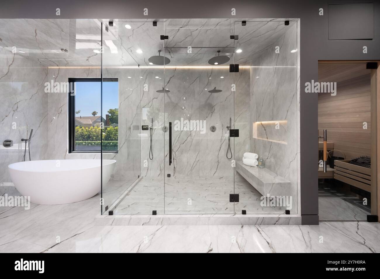 Modern luxury bathroom with a large glass shower, freestanding tub, and sauna, featuring marble ...