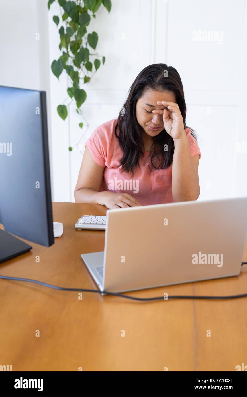 Working from home, woman feeling stressed while using laptop and ...