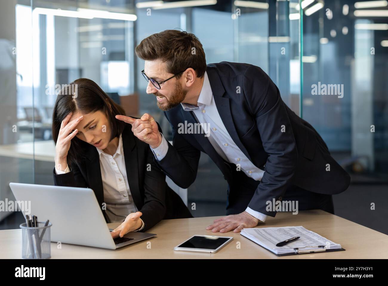 Businesswoman looking stressed as angry boss confronts her about work ...