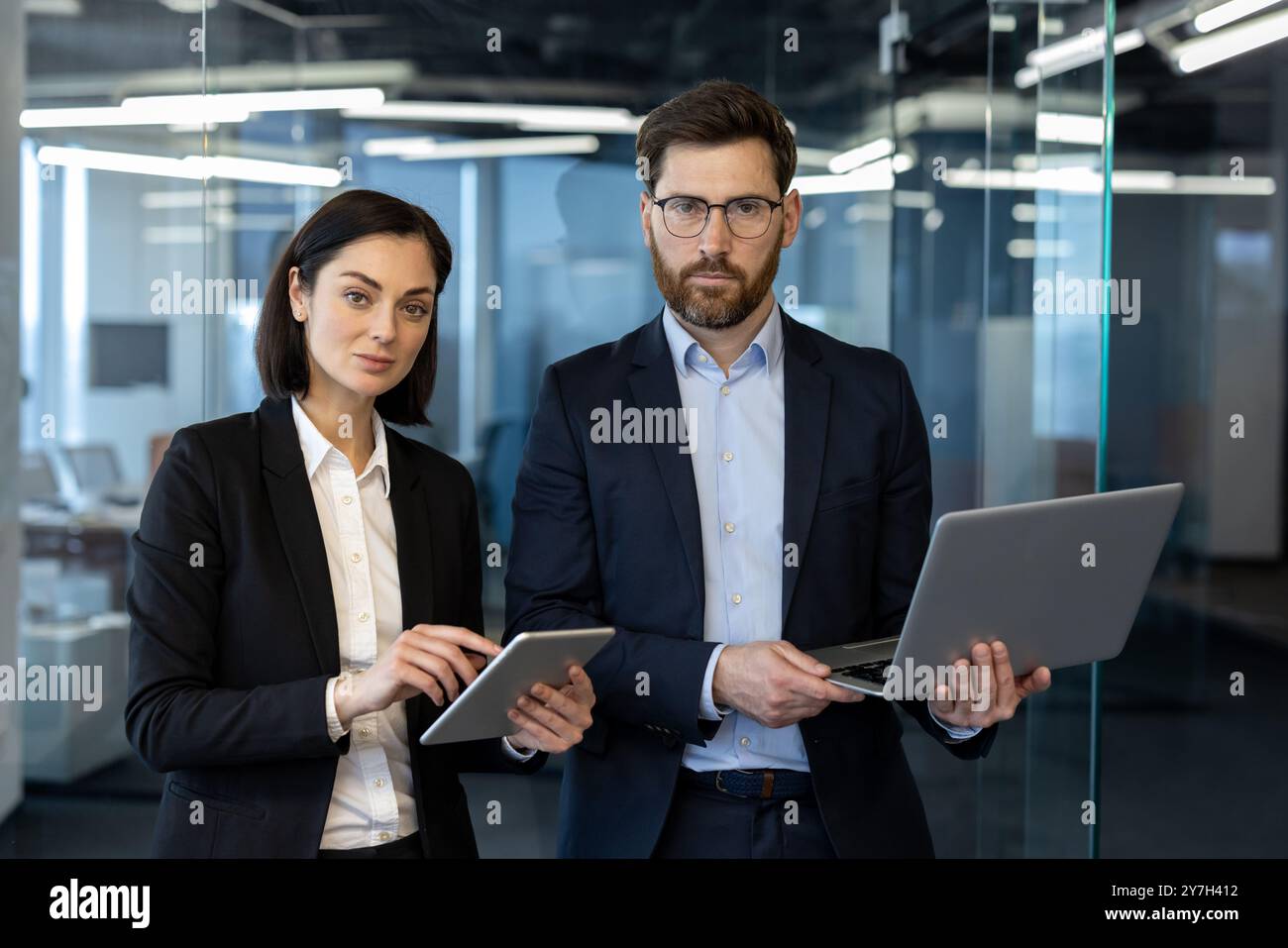 Business professionals in formal attire engage with digital devices in ...