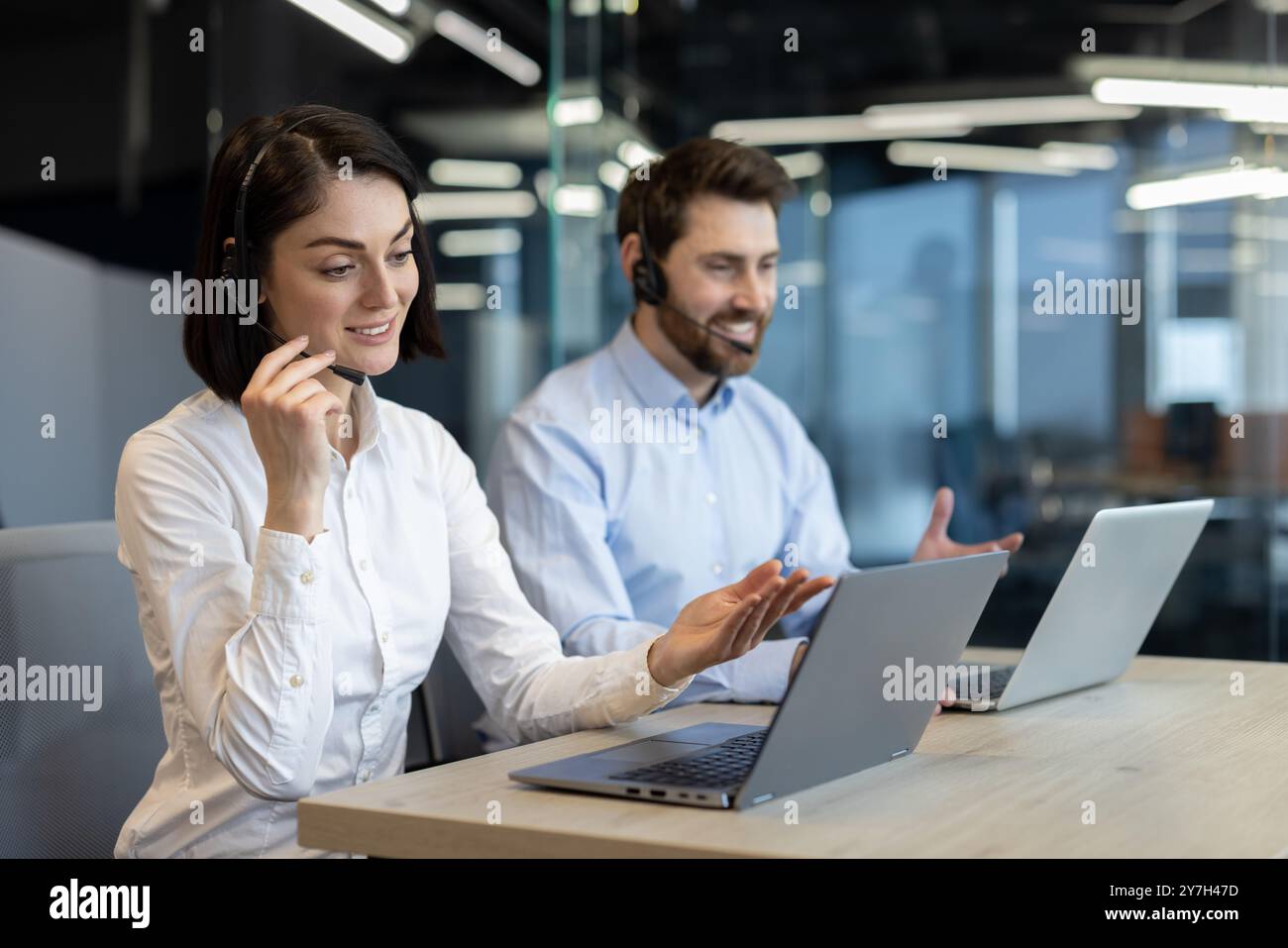 Office professionals engaged in virtual meeting, wearing headsets ...