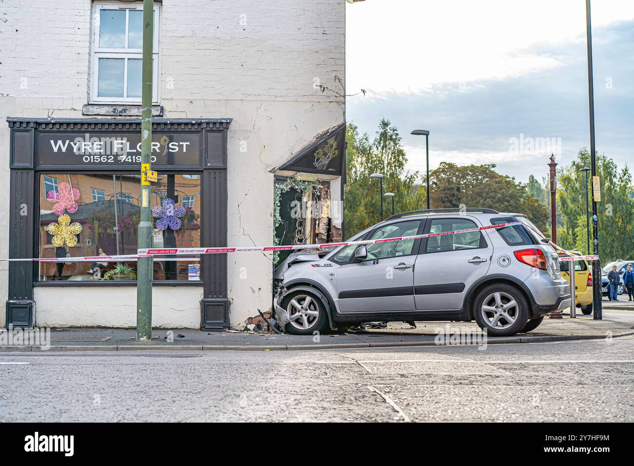Side view of a small car crashed into the entrance of a high street ...