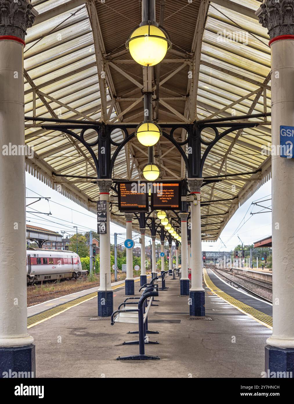 A 19th Century railway platform lined with architectural columns ...