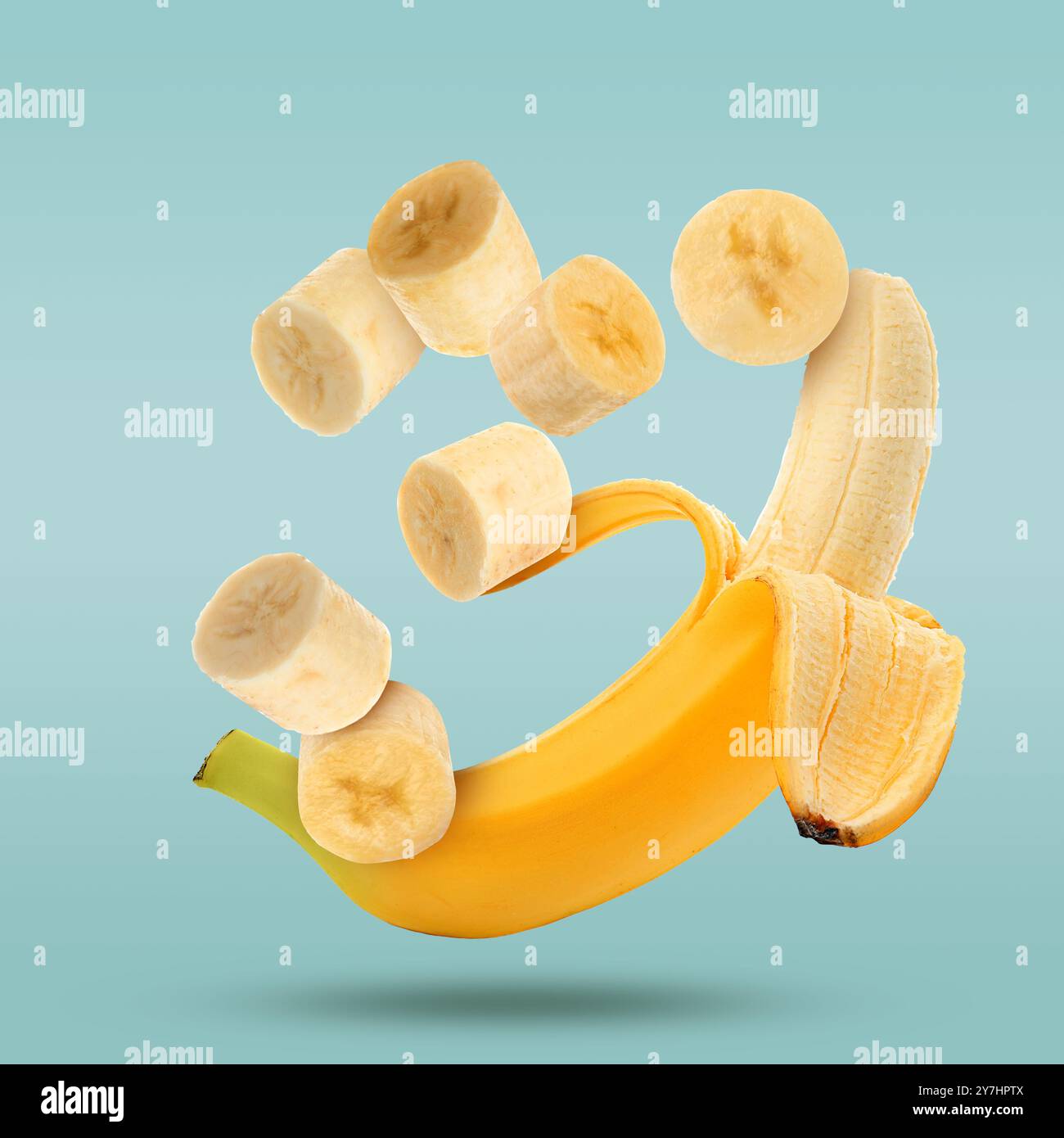 Fresh ripe bananas falling on light blue background Stock Photo - Alamy