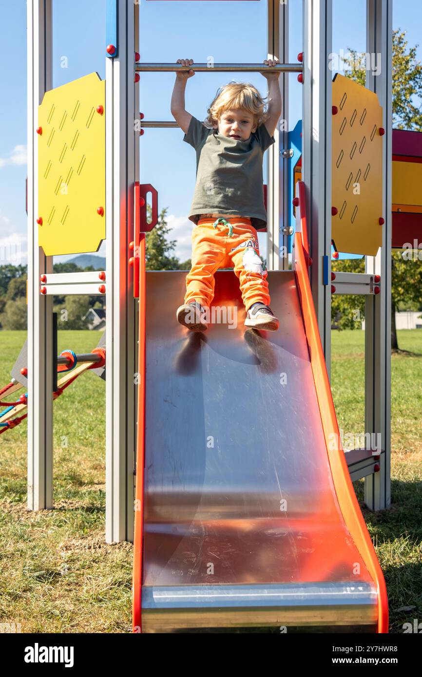 A little boy is sliding on a slide Stock Photo - Alamy