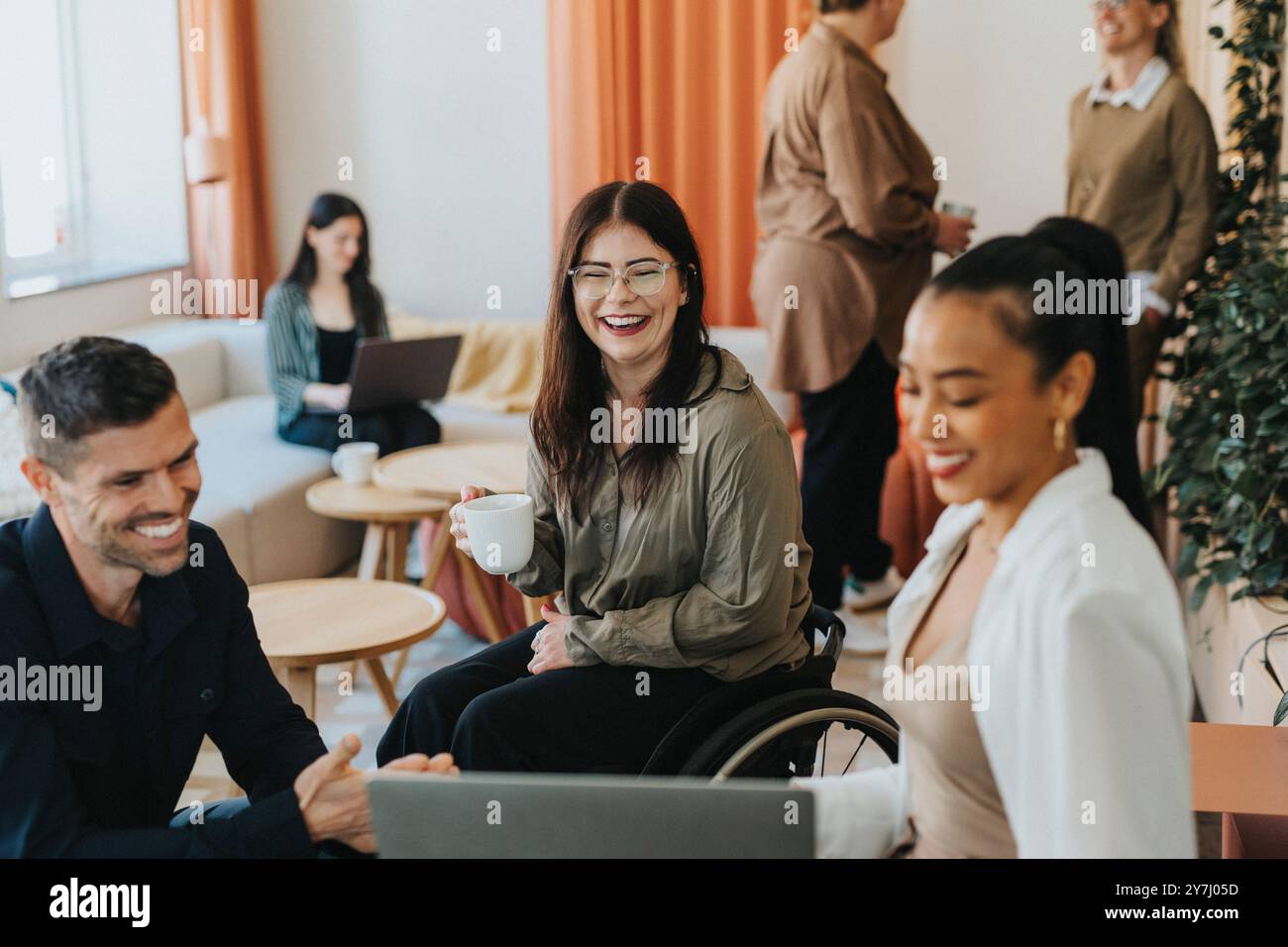 Happy female entrepreneur with physical disability discussing with ...