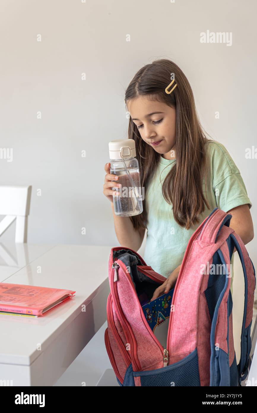 The girl packs a backpack for school. Schoolgirl with a backpack Stock ...