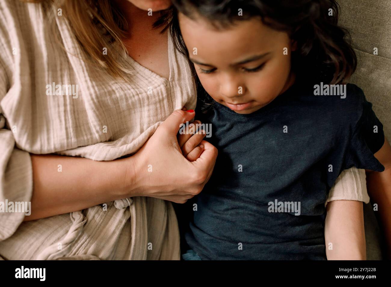 Midsection of woman holding hand of son at home Stock Photo - Alamy