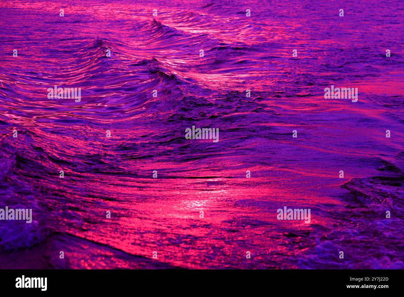 Water surface texture against the reflections of purple sunset light on ...