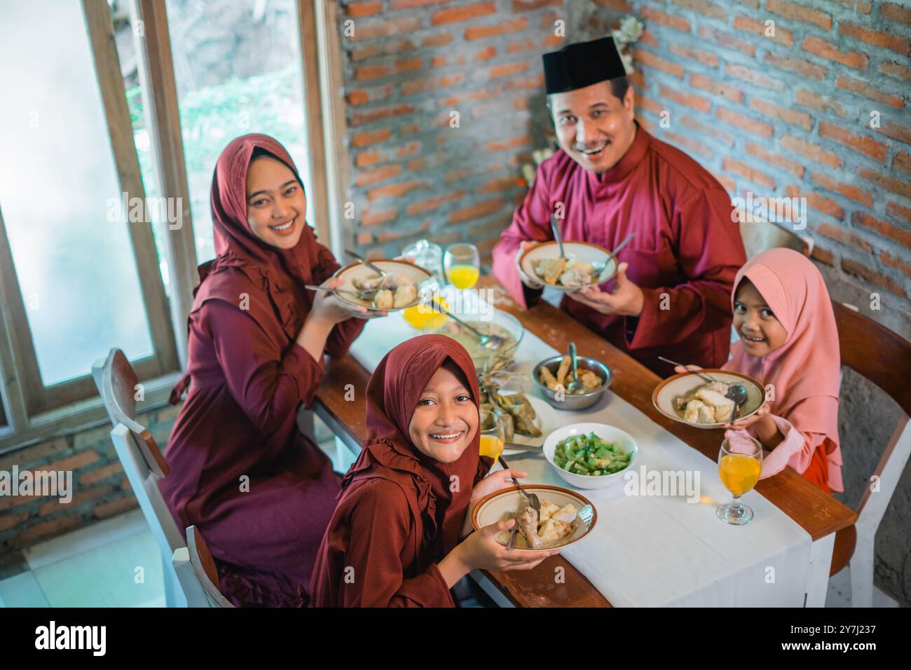 all Muslim family members smile during meals together at the dining ...