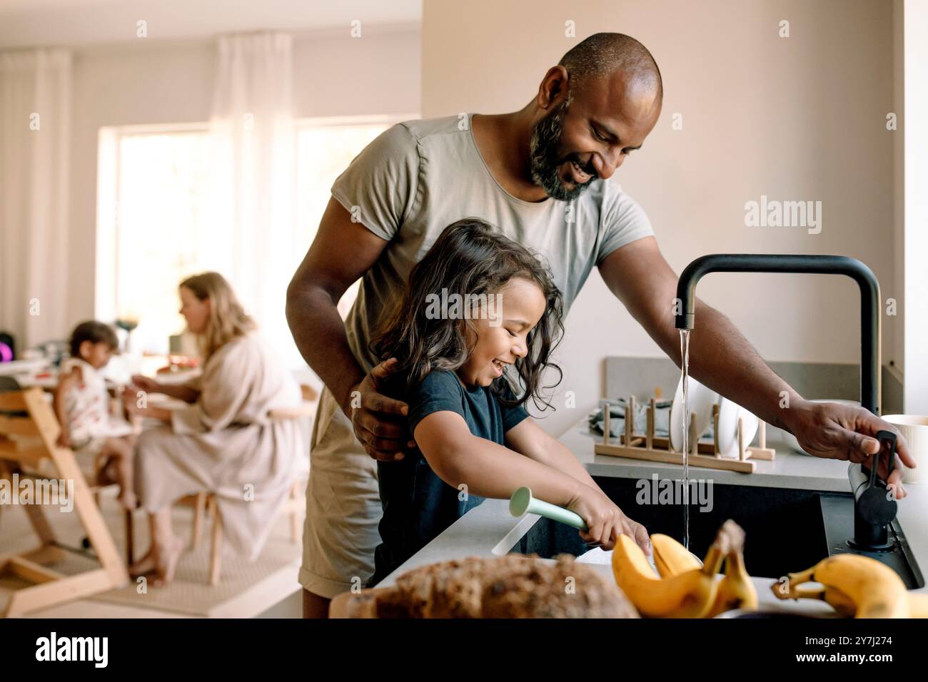 Father assisting son while washing dishes in kitchen at home Stock ...