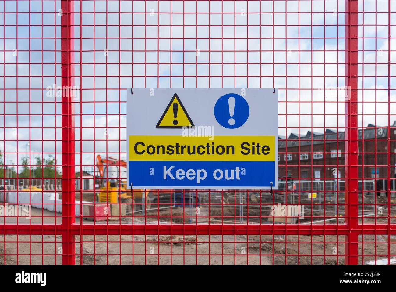 Warning sign on wire fence around building site saying construction ...