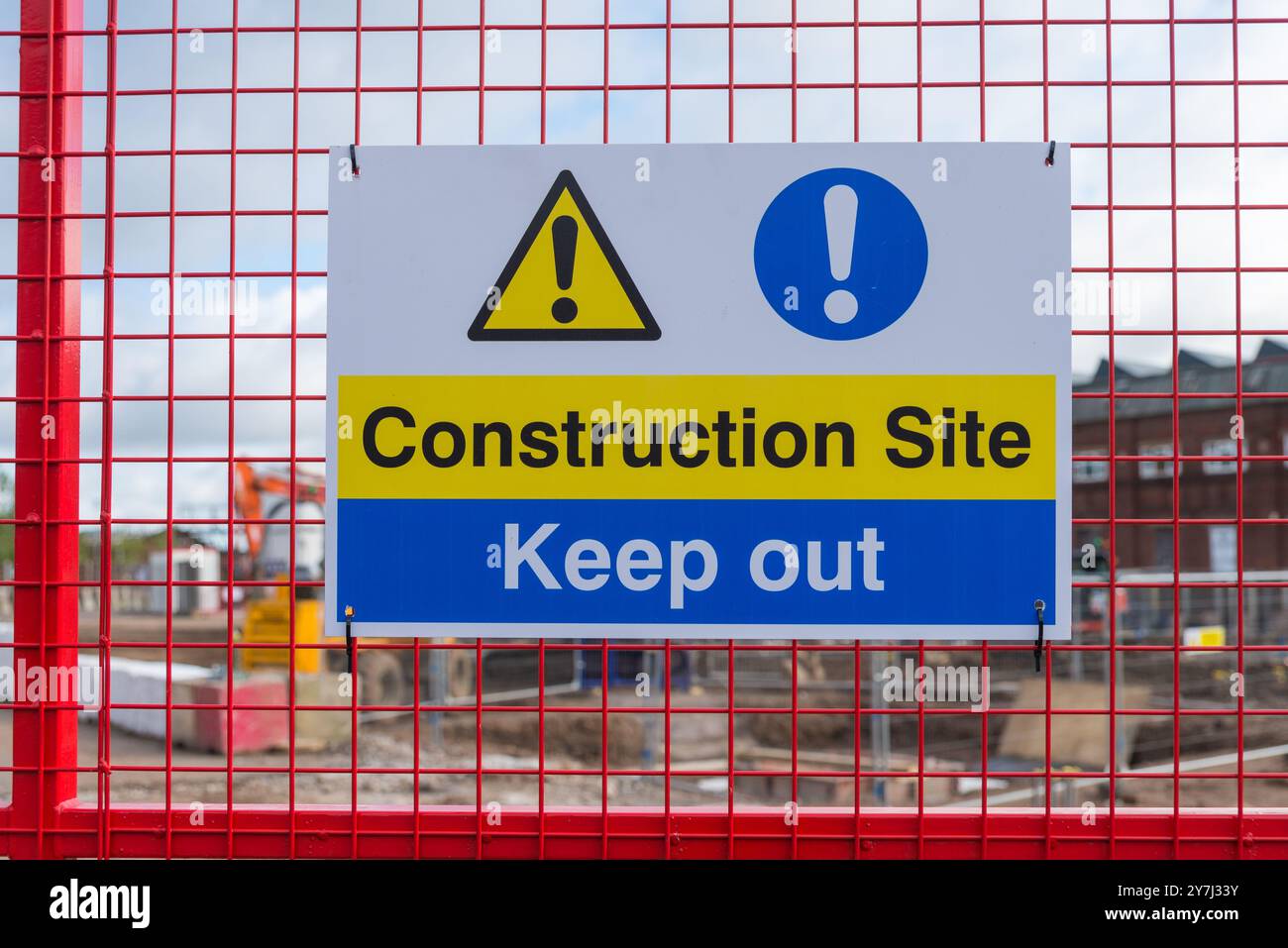 Warning sign on wire fence around building site saying construction ...