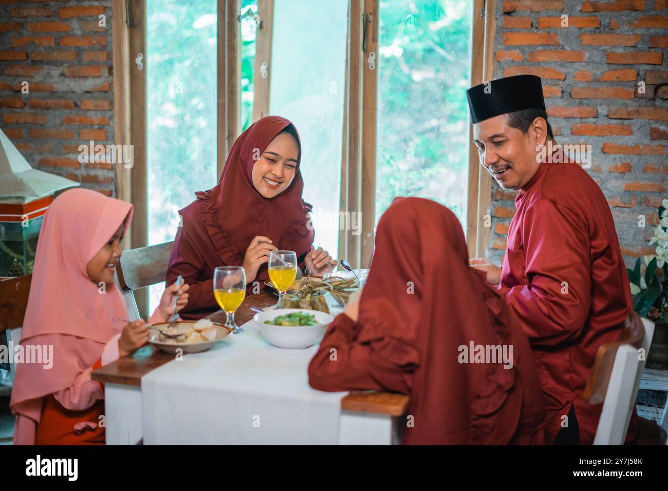 Asian Muslim family meal together at the dining table in a house Stock ...