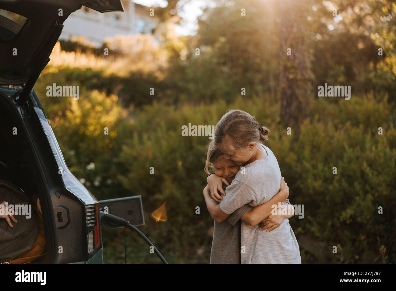 Happy brothers embracing each other while standing near car trunk Stock ...