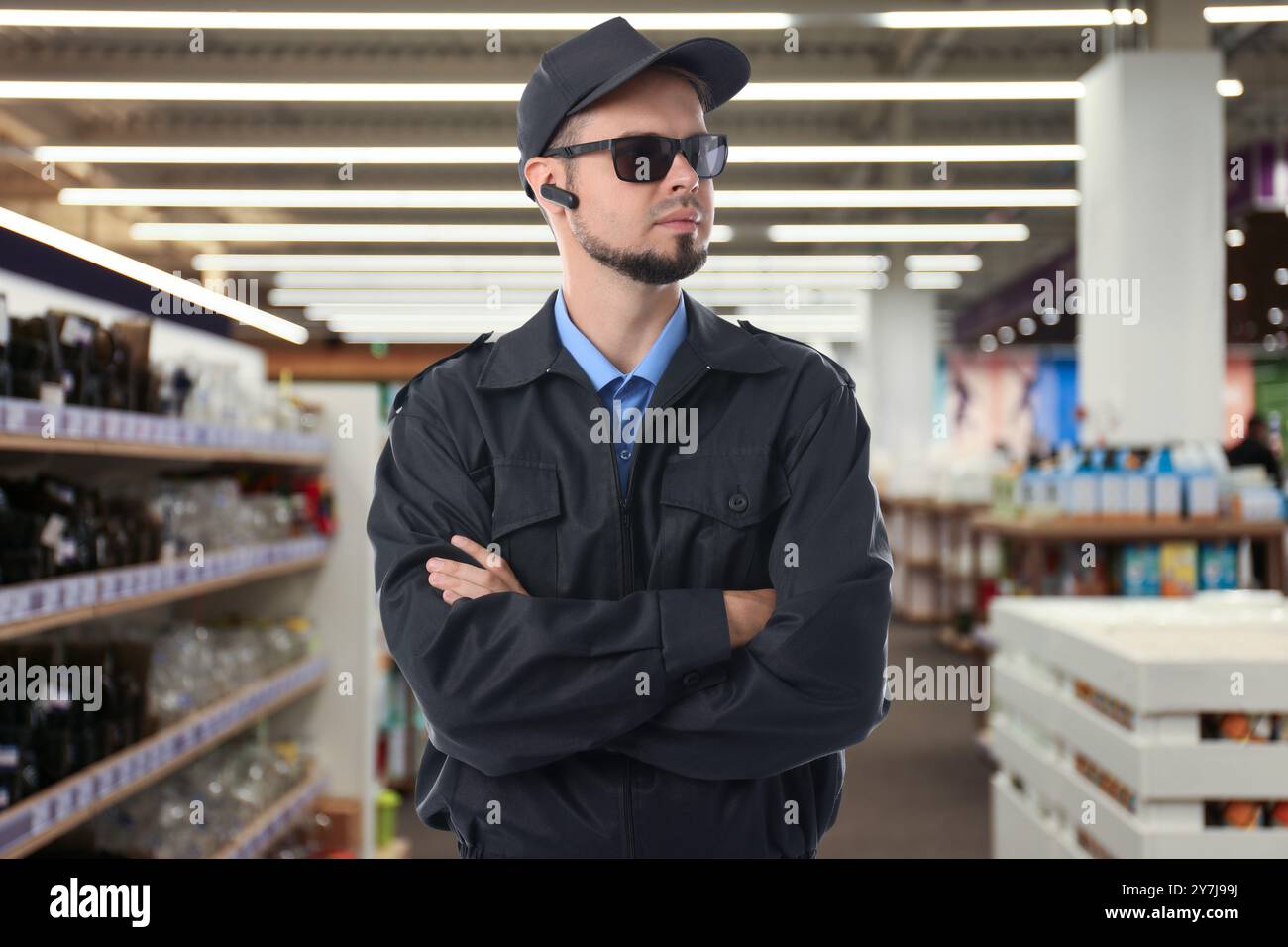 Confident security guard with earpiece in supermarket Stock Photo - Alamy