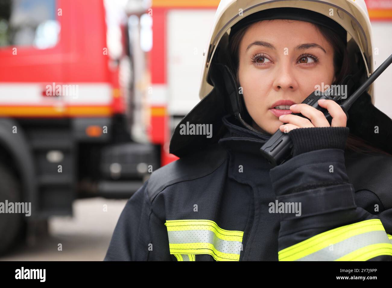 Firefighter in uniform using portable radio set outdoors, closeup Stock ...