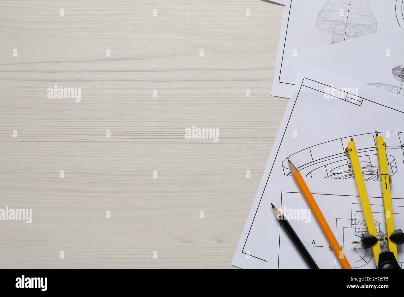 Different engineering drawings, pencils and divider on wooden table ...
