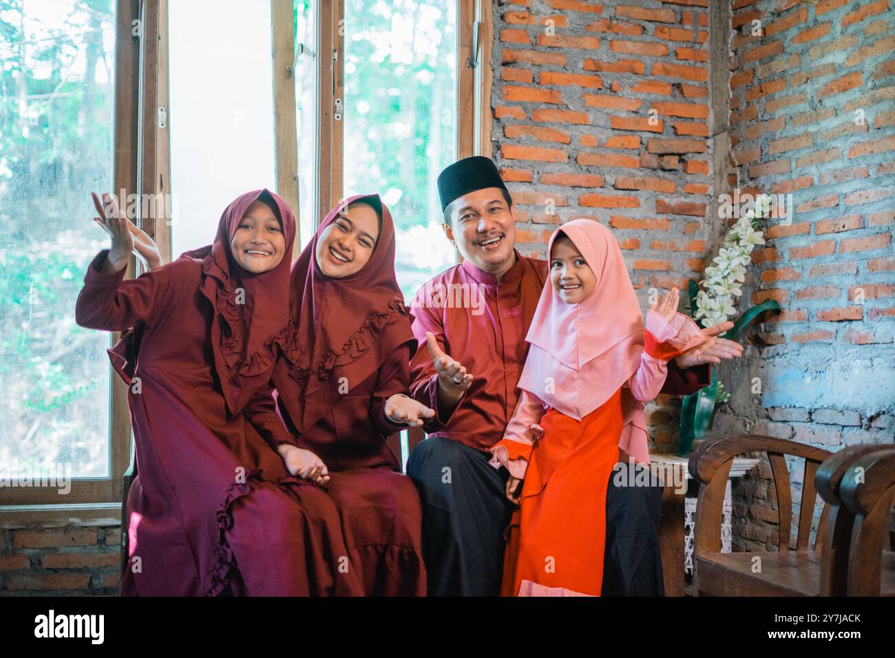 smiling Indonesian family showing hand gesture of offering something ...