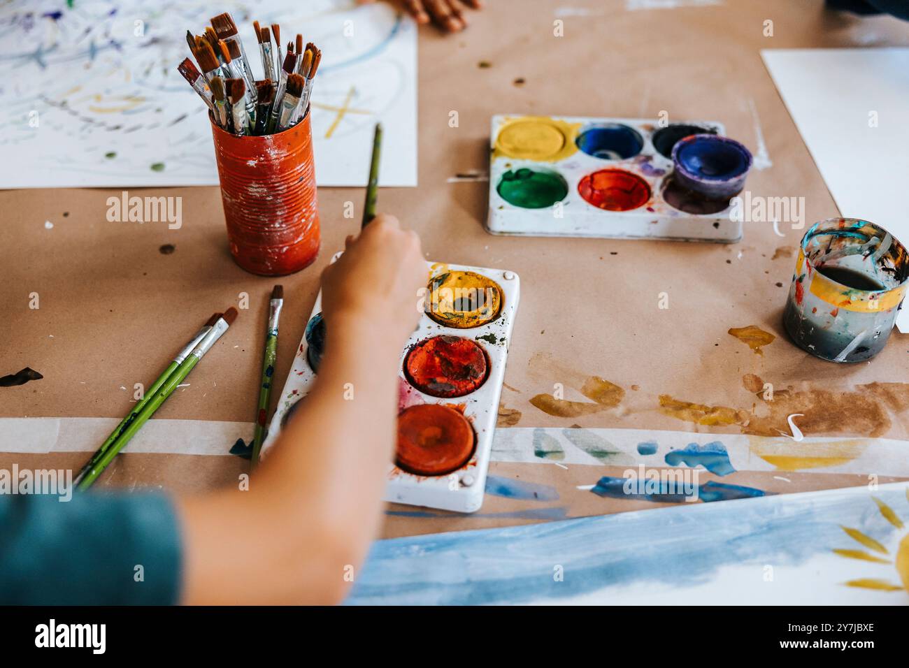 Hand of boy taking paint from palette during art class at school Stock ...