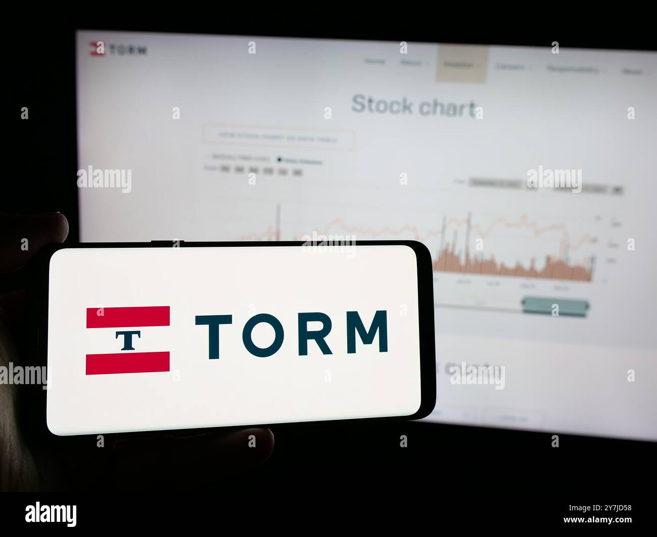 Person holding mobile phone with logo of Danish shipping company TORM ...