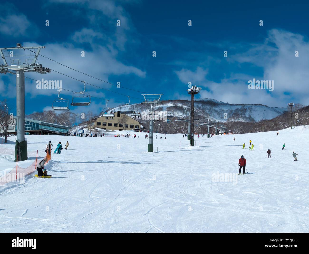 Snowboarders and skiers on the lower pistes of Niseko Annupuri ski ...