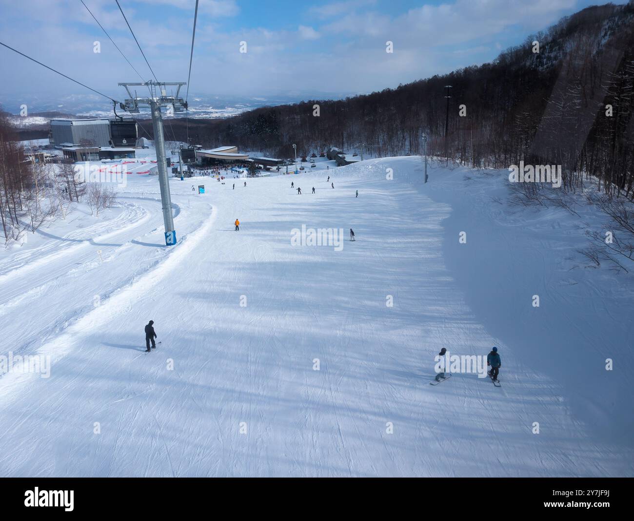 Snowboarders and skiers on the lower pistes of Niseko Hanazono ski ...