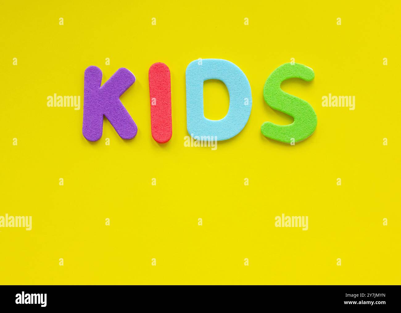 The word Kids from multi-colored letters of the alphabet on a yellow ...