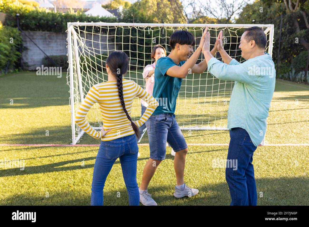 Celebrating goal, family playing soccer together on outdoor field, bonding time Stock Photo - Alamy