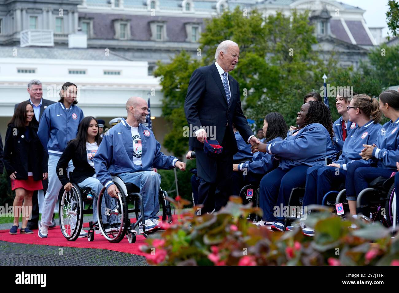 President Joe Biden, followed by U.S. Paralympian basketball player ...