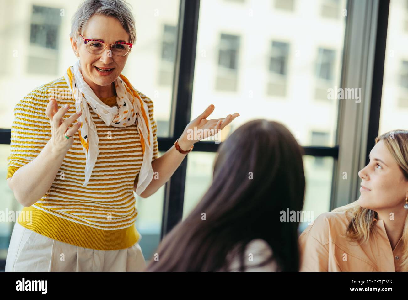 A senior lecturer interacts with college students in a city classroom ...
