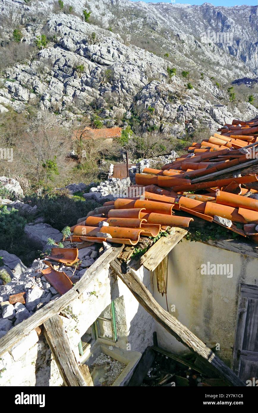 Abandoned house against the backdrop of the mountains of the Bay of Kotor, Montenegro. The ...