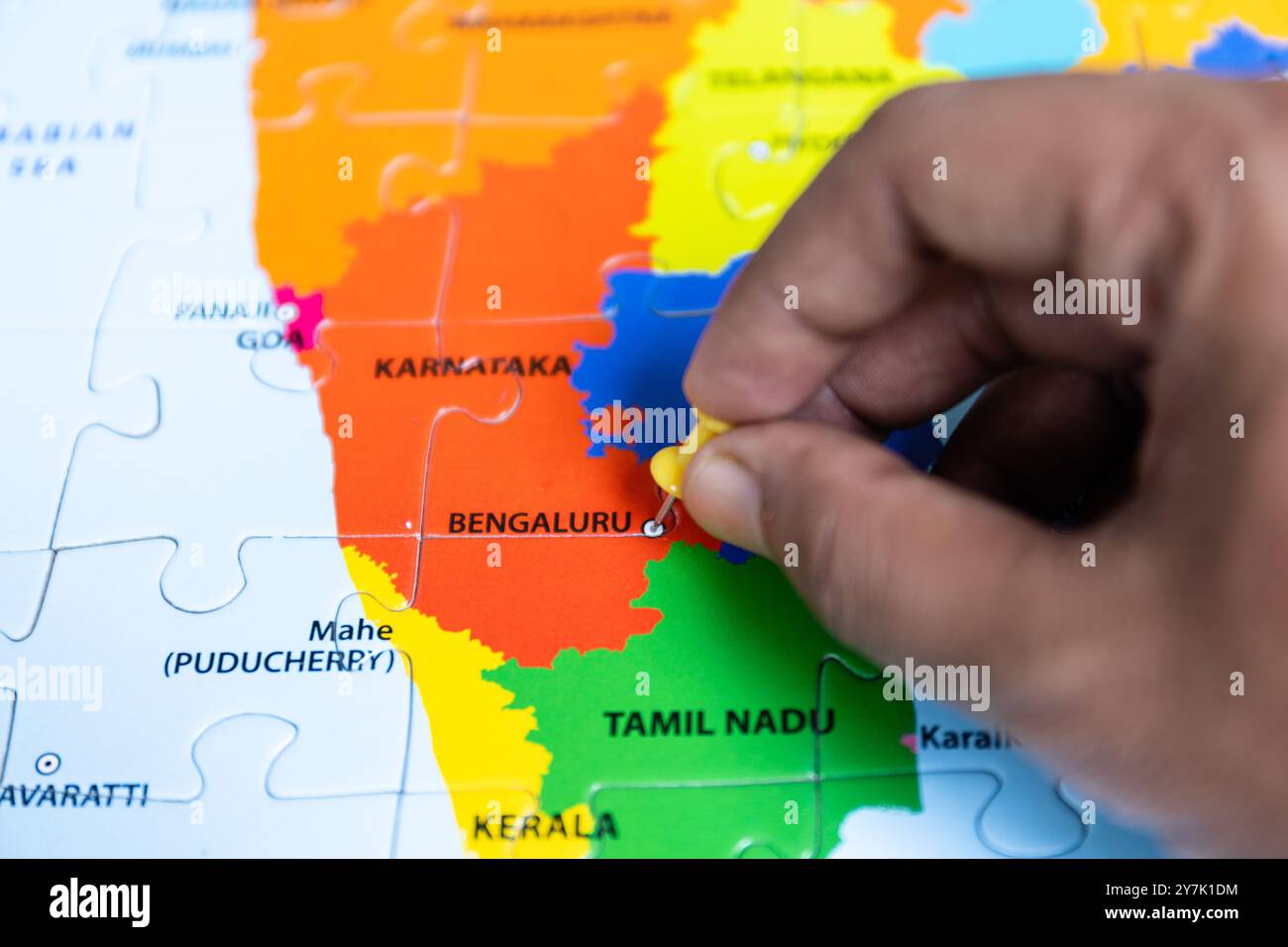 A human hand holding a map pin pointing Bengaluru - the capital of ...